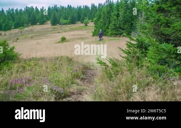 Two riders, riding their mountain bikes through rough and bushy paths ...