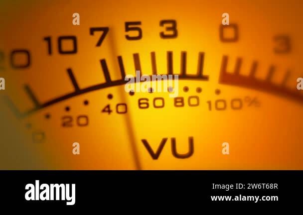 Close up shot of a vintage analog VU audio meter with a moving needle ...