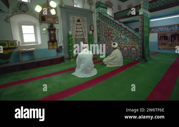 Muslim mosque teacher in a robe and turban at the small historic wooden ...