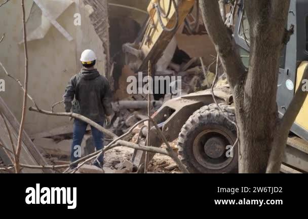 Engineer with protective helmet looks at demolition, destruction of old ...
