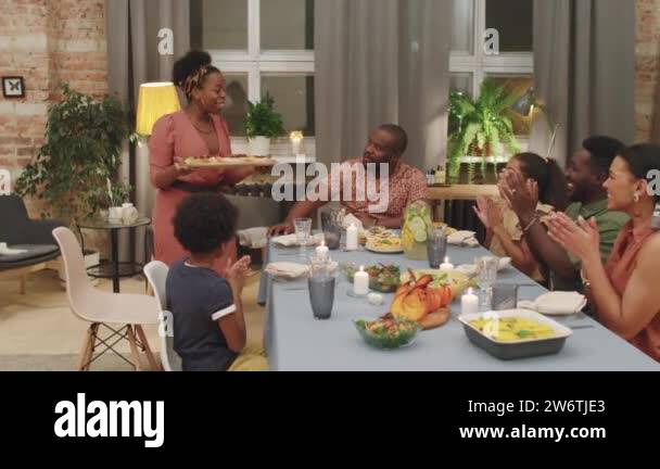 Medium PAN shot of cheerful big afro-american family having dinner ...