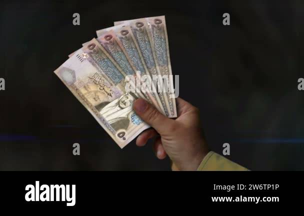 Jordan Dinar money holding. Fan of banknotes in hand. JOD paper cash ...