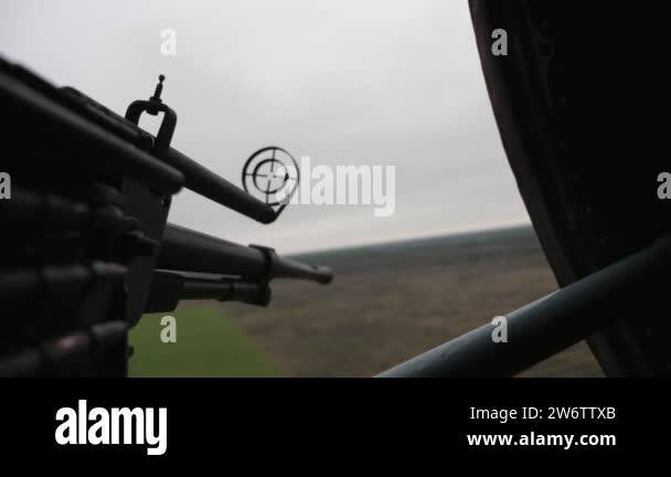 Big machine gun with a round front sight is aimed at land objects from ...