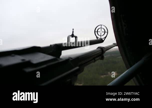 Machine gun with round front sight sticking out of a MI-8 hatch of a ...