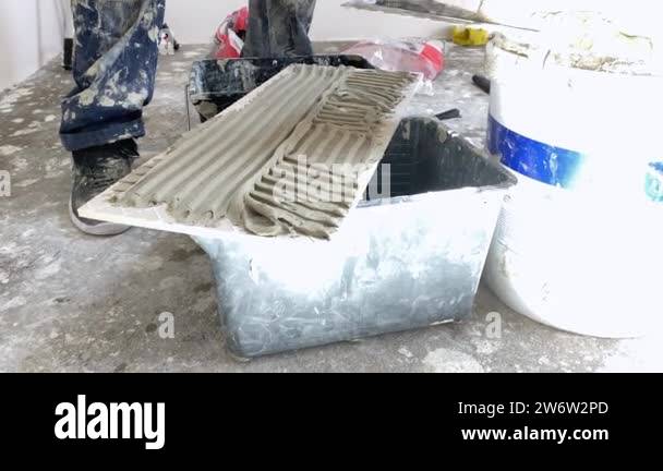 Applyng cement adhesive on ceramic tile - Installing ceramic floor ...