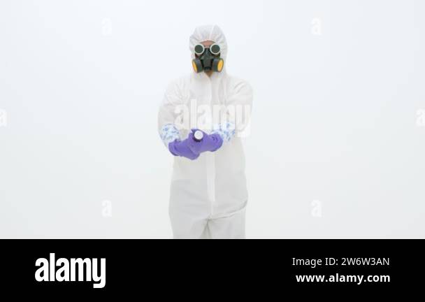 Man in white chemical protection suit and gas mask blows the party ...