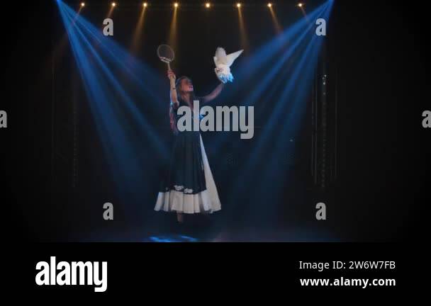 A charming woman shows tricks with a trained white dove. The bird flaps ...