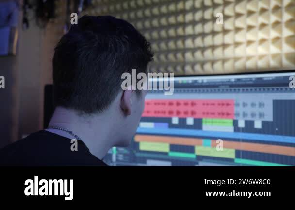 Sound engineer at music computer monitor and mixing console. Equalizer ...