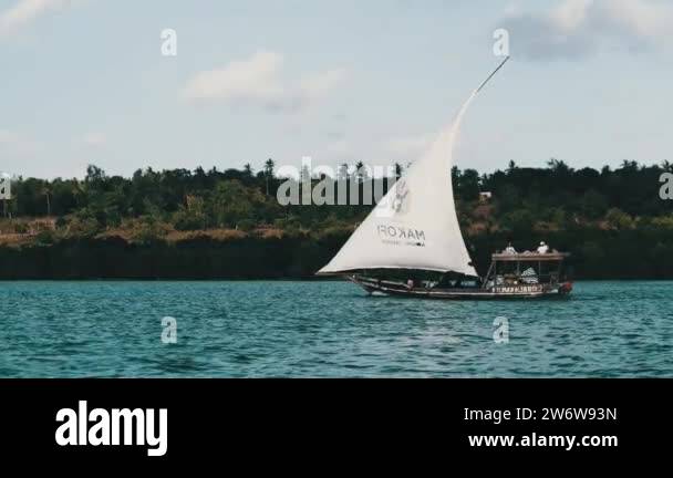 Traditional African Boat Dhow with Tourists Floats under the Open Sail ...