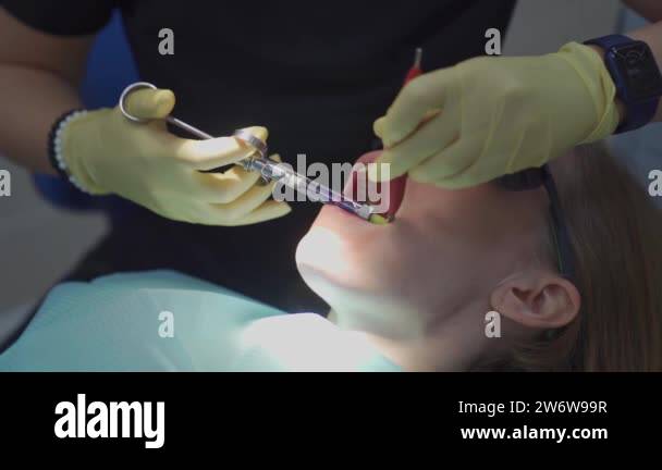 real. dentist injects an anesthetic into patient before tooth ...