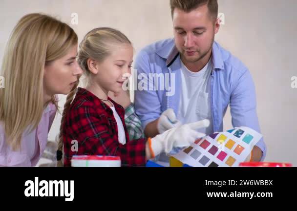 family with girl and boy with disabilities choose paint pigment from ...
