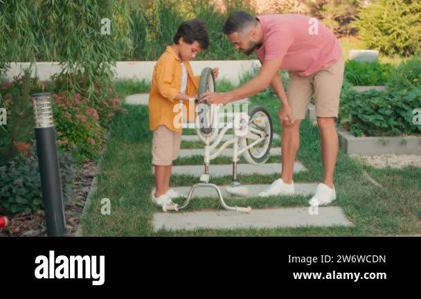 Stab side-view shot of mixed race man helping his cute little son to ...