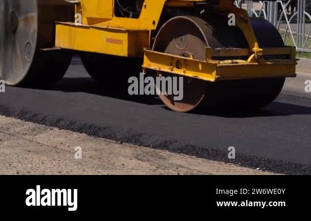 A layer of freshly laid asphalt in the rays of the setting sun. Road ...