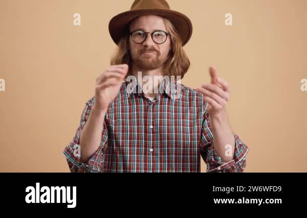 A smiling man in the hat and eyeglasses clapping hands and showing two ...