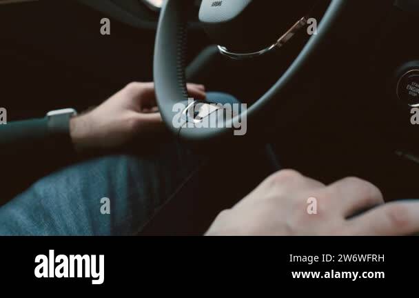 Man drives a car on auto pilot. Male hands on the knees while driving ...