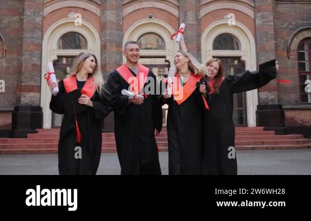 Graduates in gowns certificates with honors go to celebrate graduation ...