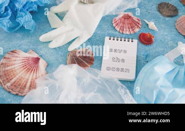 save the ocean text on blue background with sea shells and plastic ...
