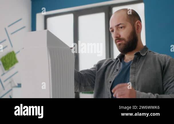 Close up of man engineer designing building model and maquette layout ...