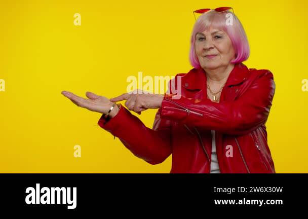Senior Old Granny Woman Showing Thumbs Up And Pointing At Left On Blank