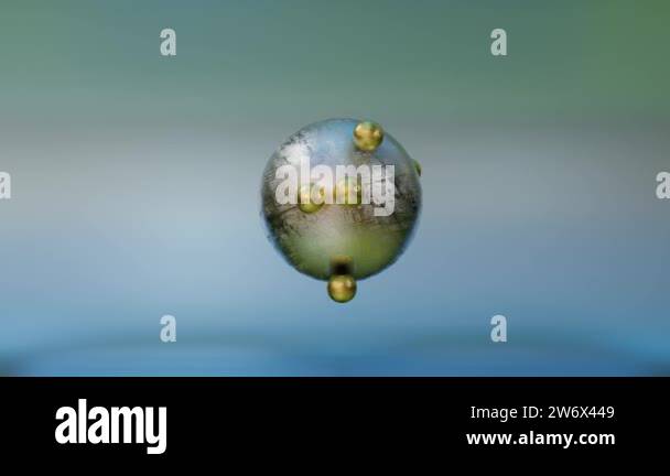 golden spheres roll over the surface of a large silvery sphere. looped ...