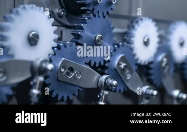 Close-up of steel gears spinning inside complex engine mechanism ...