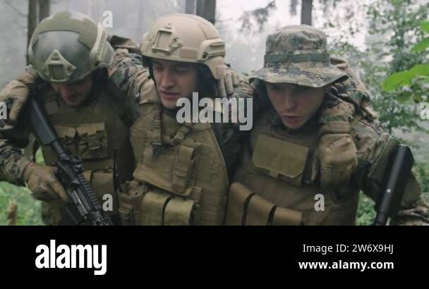 Medic troops saving soldier in dense forest during military action ...