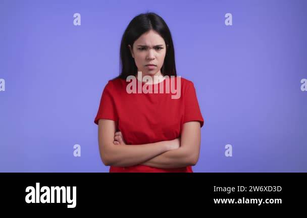 Angry offended woman keeping arms crossed and staring at camera with ...