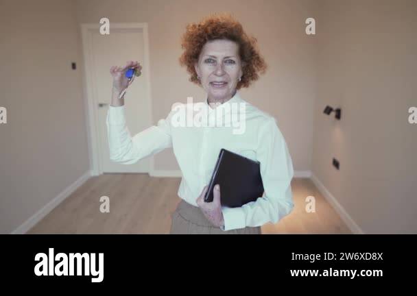 Real estate agent of mature age, realtor woman with keys in hands on ...