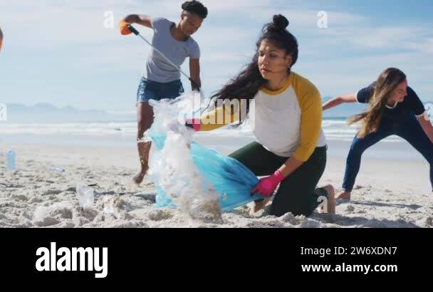 Diverse group of female friends putting rubbish in refuse sacks at the ...
