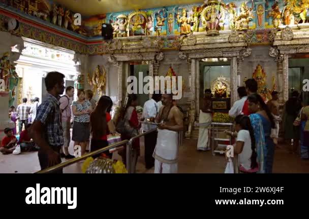 Hindu worshippers come to pray and give offerings inside a temple in ...