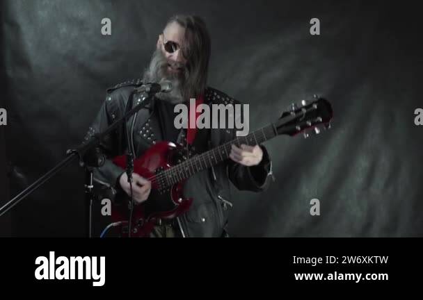 Bearded hairy rocker with shaved temples, round glasses and leather ...