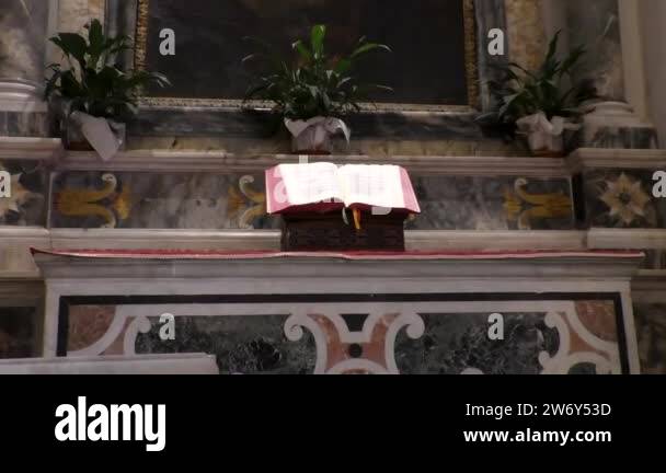 Zooming in on open English language Holy Bible book on altar in the ...
