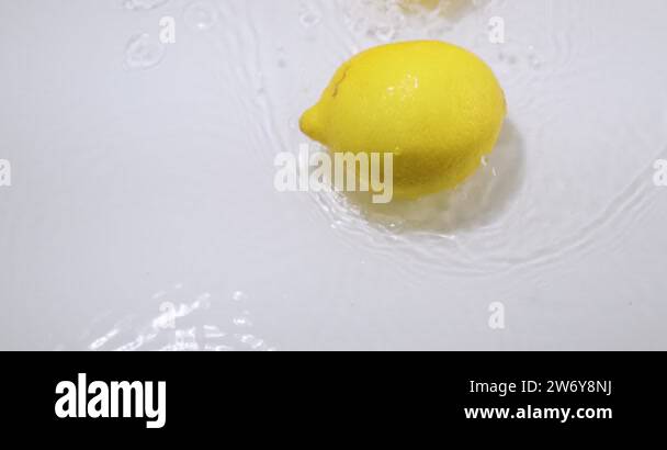 Lemons rolling on water, natural fruits citrons on white studio ...