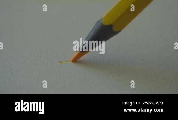 Graphite orange color pencil draws a straight line on a white ...