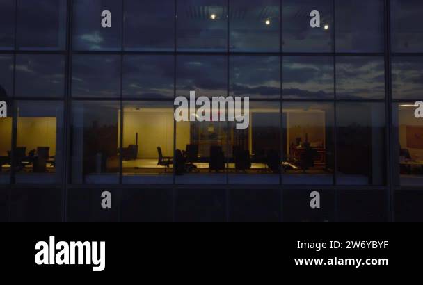 Pull back footage of offices behind windows in modern building. Full ...