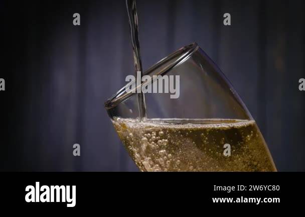Pouring light beer into a glass. Bubbles rise rapidly in the golden ...