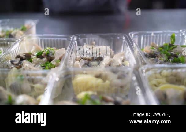 Lots of plastic disposable trays on the table with suos. The chef ...