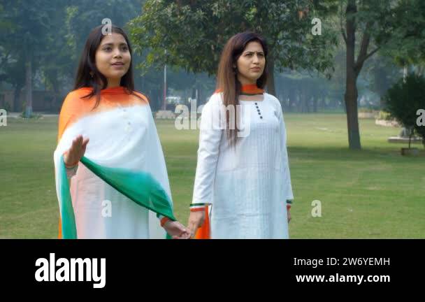 Two young women happily saluting the Indian National Flag while ...