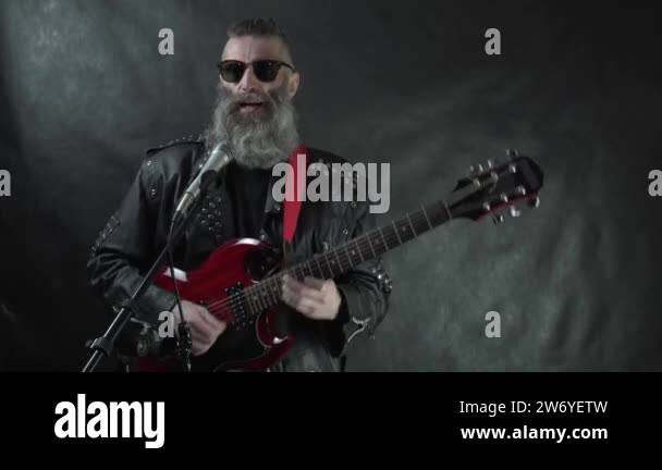 Bearded hairy rocker in retro horn-rimmed sunglasses with shaved ...