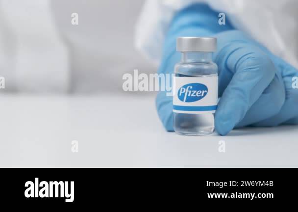 Pfizer vial with medicine put on the table by health worker in rubber ...