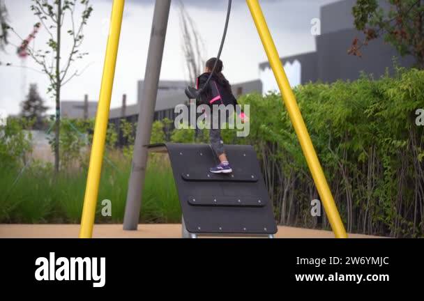 little girl playing on the playground. Happy child climbing up on ...