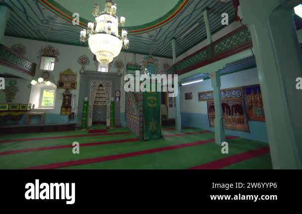 Muslim mosque teacher is reading quran in small historic wooden masjid ...