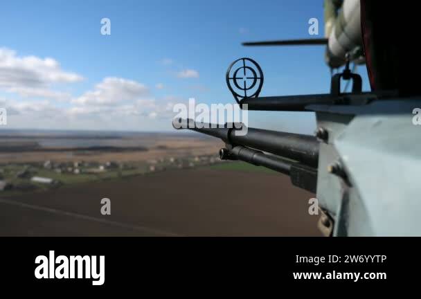 Big machine gun with a round front sight is aimed at land from a ...