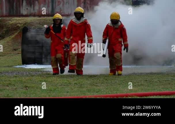 Firefighter fighting with flame using fire hose chemical water foam ...