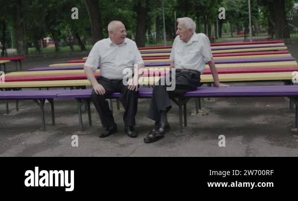 Two modest seniors friends tell funny stories remembering youth time ...