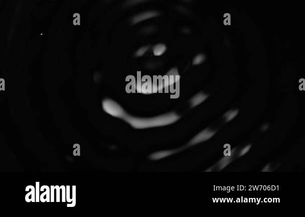 Splashes and drops on the surface of the liquid. Abstract Black ...