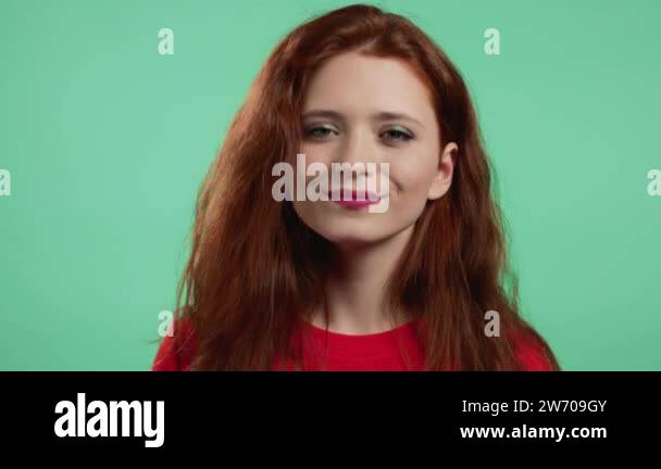 Woman with red hairstyle showing yes sign, nods her head approvingly ...