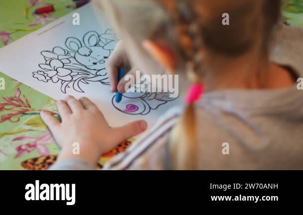 Children. The hands of a little girl who carefully paints the drawing ...