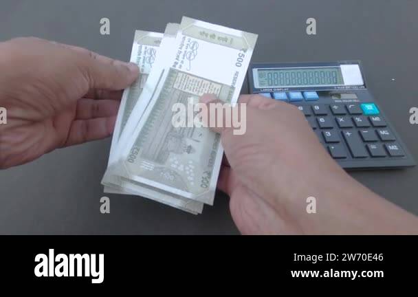Human hand counting new 500 rupee indian currency note against a ...