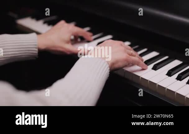 The pianist performs playing a grand piano. Man two hands plays gentle classical music on a ...